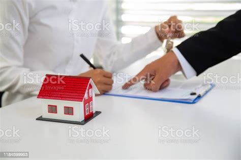 한 여성이 부동산 중개인과 주택을 구입하는 계약서에 서명합니다 테이블에 키가있는 모델 하우스 가정 생활에 대한 스톡 사진 및 기타 이미지 Istock