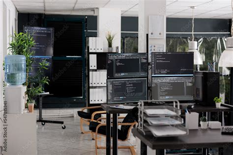 Desk With Multiple Pc Monitors Compiling Terminal Window And Artificial Intelligence Coding