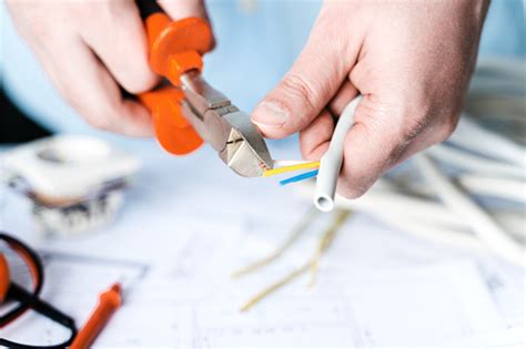 남자 집에서 전기 프로젝트를 만드는 수리공 수리 계획 도면 다이어그램 아파트 건물의 전기화 계획 장치 액세서리 전압계 전선 스크루 드라이버 펜치 테이프 측정 3차원 형태에