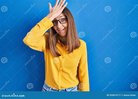 Young Woman Wearing Glasses Standing Over Blue Background Surprised