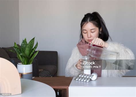 아시아 소녀 복용 약 알약 집에서 보충제 겨울 옷과 스카프 붓는 물 겨울에 대한 스톡 사진 및 기타 이미지 겨울 기침하기