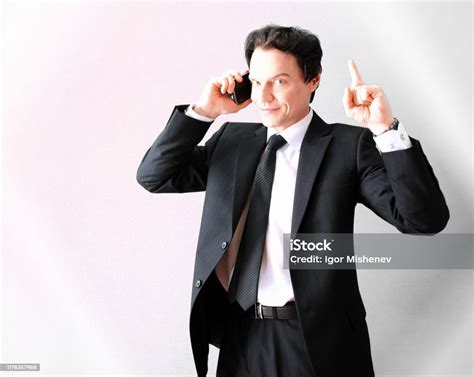 의도적 인 매력적인 사업가 스마트 폰에 이야기 카메라를보고 미소와 흰색 배경에 손가락을 보여줍니다 아이디어가 있다 성공으로 가는 길에 비즈니스 라이프 감정 시리즈에 대한