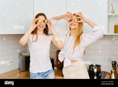 Two Playful Women Put Pieces Of Cucumber To Their Eyes Have Fun In The