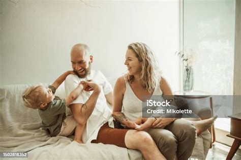 부모 자녀 그리고 가족과 함께 집 거실의 소파에 앉아 유대감을 형성합니다 어머니 아버지 아이들이 귀여운 아기와 장난기 많은