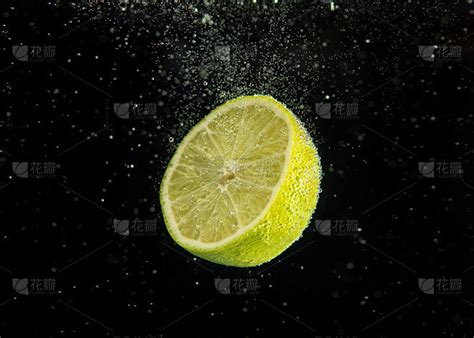 在黑色背景中石灰上的气泡被抛入水中石灰细节和重点