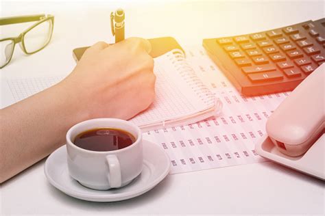 회계사는 책상에서 연례 보고서를 작성합니다 커피 한 잔 계산기 메모장 및 전화 회계 및 재무 개념에 대한 스톡 사진 및 기타