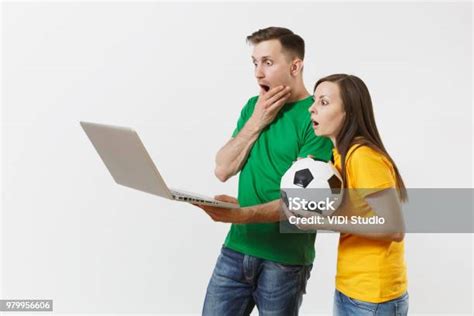 충격된 커플 여자 남자 노란색 녹색 T셔츠 팬 들 축구 축구 공 흰색 배경에 고립 된 Pc 노트북에서 게임을 보고 지원 팀 응원 합니다 스포츠 가족 레저 라이프 스타일