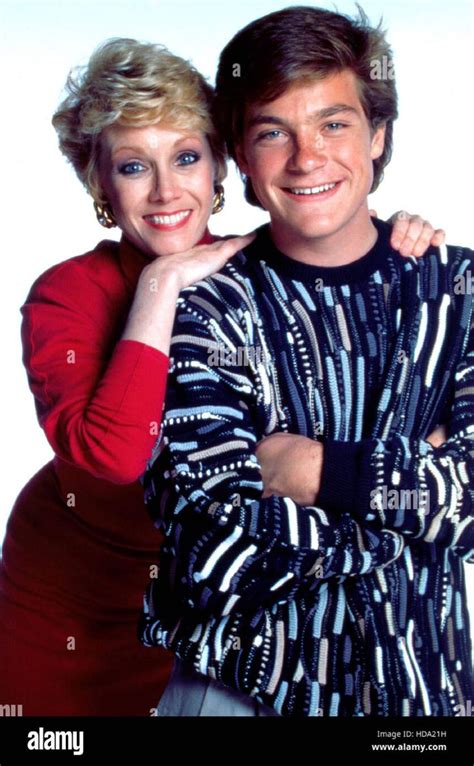 Two People Are Posing For The Camera With Their Arms Around Each Other