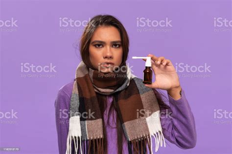 스웨터와 아늑한 체크 스카프에 예쁜 아프리카 계 미국인 소녀는 보라색 배경 위에 고립 된 차가운 서있는 코 스프레이 비쿠아제를 사용하는 데 지쳤습니다 가을에 대한 스톡 사진