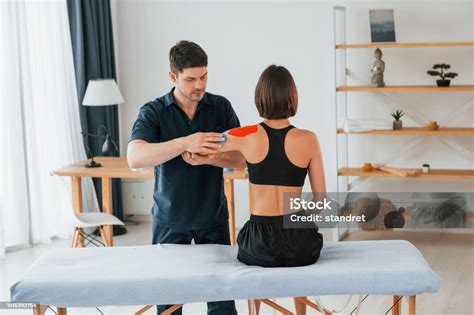 현대적인 배경 피부에 키네시오 테이프를 붙이는 생리학자를 방문하는 여성 25 29세에 대한 스톡 사진 및 기타 이미지 25 29세 2명 30 34세 Istock