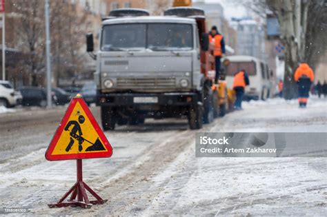 눈과 얼음으로 얼어붙은 겨울 도로를 맑게 하는 스노우블로어 눈 쟁기는 도시 거리에서 눈을 제거합니다 경고 도로 표지판 겨울 서비스 차량 눈 송풍기 작업 눈 덮인 얼어붙은
