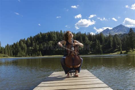 Bella Joven Y Ex Mujer Toca Su Violonchelo En Un Espigón De Madera Foto de archivo Imagen de
