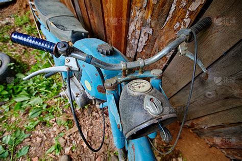 一个废弃的摩托车摊在村子的篱笆旁