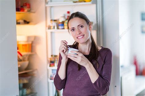 Woman Eating Yoghurt Stock Image C Science Photo Library