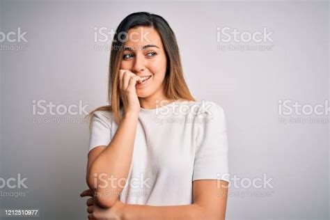 젊은 아름 다운 금발 여자 푸른 눈을 입고 캐주얼 티셔츠 위에 흰색 배경 찾고 스트레스와 긴장 입 물고 손톱에 손으로 불안 문제 T 셔츠에 대한 스톡 사진 및 기타 이미지