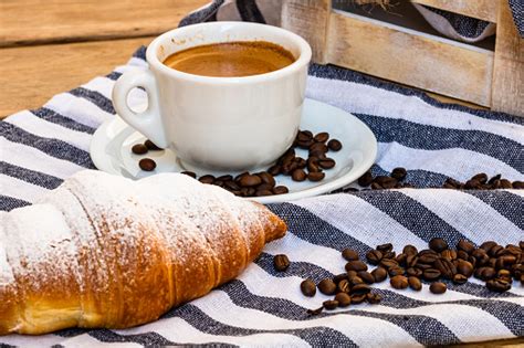 퍼프 페이스트리 커피 컵 버터를 넣은 프렌치 크루아상을 나무 상자위에 넣습니다 음식과 아침 식사 개념 커피 디저트와 신선한