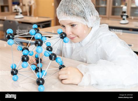 A Babegirl In A White Coat Demonstrates An Atomic Model Of A Molecule Using A Set Of Three