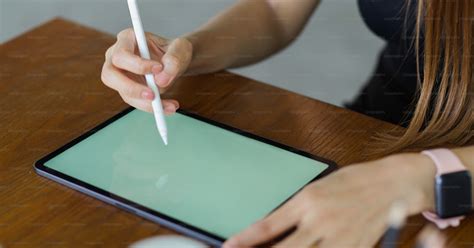 나무 테이블에 스타일러스 펜으로 디지털 태블릿을 사용하는 여성 손의 자른 샷 사진 Unsplash의 컴퓨터 이미지