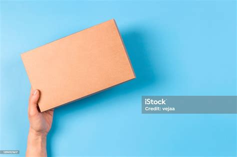 밝은 파란색 배경에 갈색 판지 상자를 들고있는 여성의 손의 상단보기 모형 소포 상자 포장 쇼핑 배달 개념 상자에 대한 스톡 사진 및 기타 이미지 Istock
