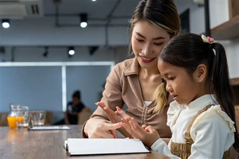 사랑스러운 딸에게 거실에서 숙제를 가르치는 아름다운 어머니 20 24세에 대한 스톡 사진 및 기타 이미지 20 24세 2명