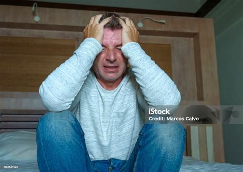 30 대 40 대의 극적인 홈 초상화 우울 하 고 고통 침대에 앉아 통증 불안 위기와 우울증 문제 울고 슬픔과 좌절 느낌 압도