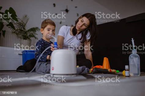 어머니와 아들은 집에서 분무기를 흡입하고 책을 읽습니다 기침하기에 대한 스톡 사진 및 기타 이미지 기침하기 원조 아이 Istock