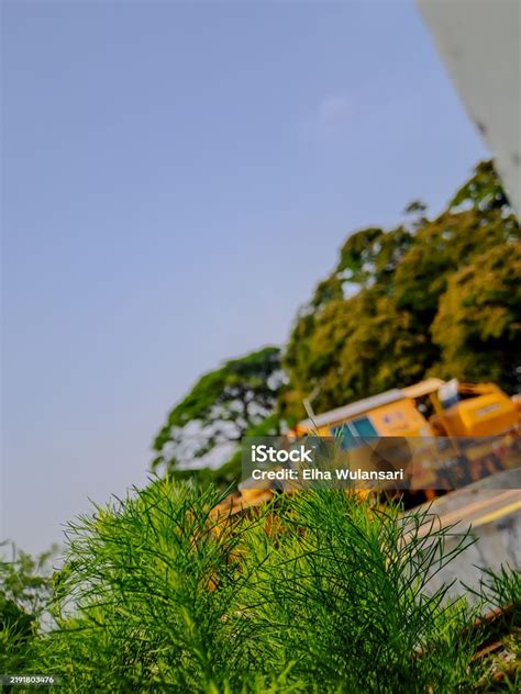 철도 선로의 한 부분에 주차된 무거운 노란색 철도 유지 보수 기계 기계는 선로 유지 보수 및 수리에 사용되는 밸러스트 레귤레이터 또는 이와 유사한 장비로 보입니다 0명에