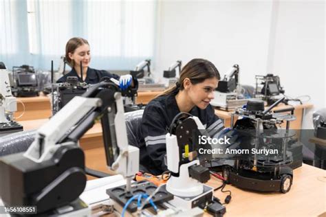 두 명의 여성 엔지니어 작업자 교육 또는 유지 보수 제조 자동화 및 로봇 아카데미 룸의 Ai 로봇 및 사물 인공 지능 서비스