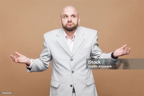 몰라요 혼란된의 손에 잘생긴 중간 세 대머리 수염된에서 사업가 고전적인 빛 회색 양복 서 생각 하 고 넘어 갈색에 대한 스톡