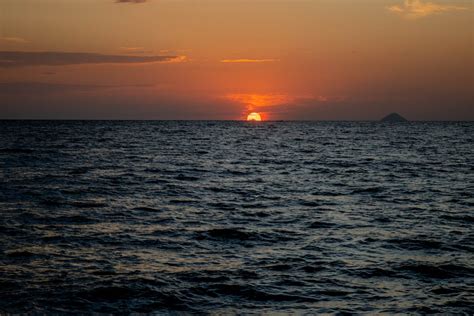 먼 섬과 함께하는 극적인 바다 일몰 · 무료 스톡 사진