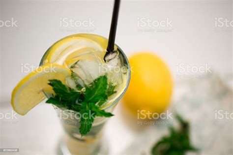 건강 한 레몬과 민트 잎 옆 레몬과 냅킨으로 흰색 나무 테이블에 칵테일 잔에 물 해독 무알코올 모 히 토 또는 아이스 큐브 평면도와 레모네이드 0명에 대한 스톡 사진 및