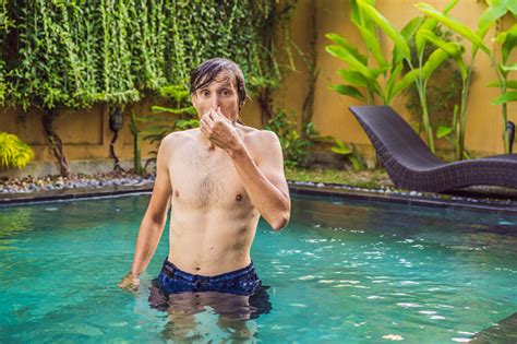 그의 얼굴에 혐오와 젊은 남자 핀치 코 뭔가 냄새 수영장 화학 물질 때문에 수영장에서 매우 나쁜 냄새 부정적인 감정 얼굴 표정 가리기에 대한 스톡 사진 및 기타 이미지