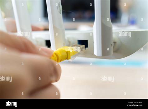 Asian Woman Plugging Network Cable Into Router Stock Photo Alamy
