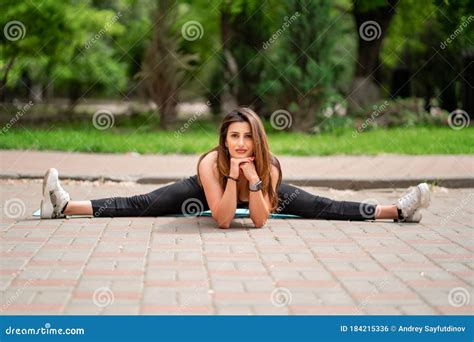 Girl Athlete In Sports Apparel Stretching Sitting On The Splits In
