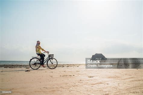 탄자니아 잔지바르 섬의 키웬와 해변에 있는 외로운 썰물 바다 하얀 모래 해안에 앞바구니가 달린 오래된 빈티지 자전거를 타고