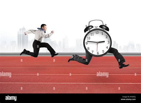 Man Running After Alarm Clock Of Running Legs On Red Running Track With City Skyline Background