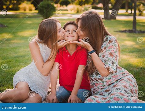 Happy Mother Son And Daughter In The Park Mom And Sister Kiss Their