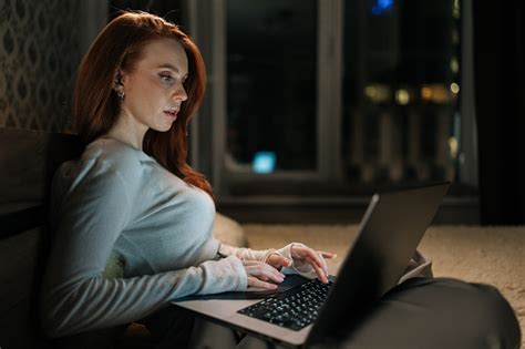 집중하는 여성 프리랜서의 측면 모습 밤에 집에서 원격으로 일하고 노트북에 타이핑하고 침대에 편안하게 앉아서 작업에 집중합니다 가정 생활에 대한 스톡 사진 및 기타 이미지