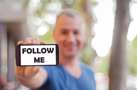 남자는 팔로우 Me 옵션으로 모바일 스마트 폰 빈 화면을 보여줍니다 고객 참여에 대한 스톡 사진 및 기타 이미지 고객 참여 공란 광고 Istock