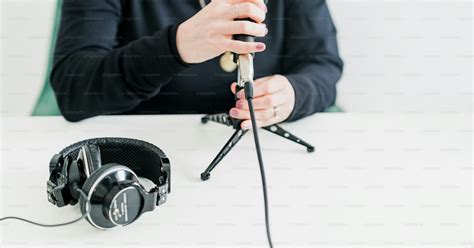 마이크와 헤드폰을 들고 테이블에 앉아 있는 여자 사진 Unsplash의 팟캐스트 마이크 이미지