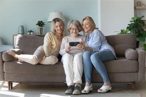 Grandmother With Mature Daughter And Granddaughter Spend Leisure Using