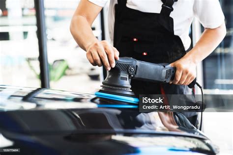 전문 자동차 연마의 자르기 이미지는 검은 자동차 후드에 연마 스크래치를 제거하고 실제 빛나는 자동차 페인트를 복원하는 궤도 연마기를 문질러 자동차 청소 및 코팅 서비스 차에