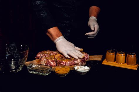 흰색 장갑을 낀 셰프는 돼지고기 조각을 향신료로 문지르고 카레 바질 소금을 사용하고 바비큐에 고기를 양념합니다 고급에 대한 스톡 사진 및 기타 이미지 Istock