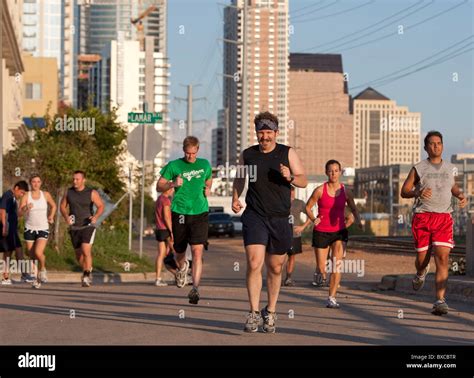 Men And Women Jog Across Street During Exercise Class In Downtown