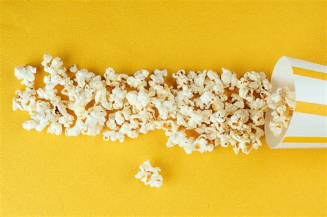 노란색 배경에 종이 줄무늬 컵에서 흩어져있는 팝콘 영화관에서 홈 시네마와 영화의 개념 가득 찬에 대한 스톡 사진 및 기타 이미지 가득 찬 건강에 좋지 않은 음식