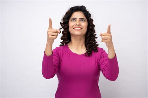 매력적인 좋은 현대 아름 다운 곱슬 머리 행복 한 젊은 여자의 초상화는 흰색 배경 스톡 사진 위를 가리키는 빈 공간 손가락을 나타냅니다 30 34세에 대한 스톡 사진 및