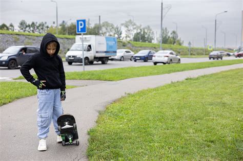 복사 공간 도시 거리에서 스케이트보드를 탄 소년 한 아이가 보도에서 스케이트보드를 타는 법을 배운다 세련된 소년이 스케이트 보드를 타고 도시 주변을 산책합니다 생활방식