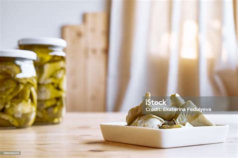 올리브 오일과 허브로 절인 아티초크 하트 나무 테이블에 흰색 접시에 마늘과 절인 아티 초크 수제 건강 식생활 아티초크에 대한 스톡 사진 및 기타 이미지 Istock