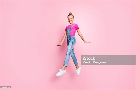 분홍색 파스텔 색상 배경을 통해 고립 된 청바지 데님을 입고 가는 쾌활한 귀여운 좋은 이빨 소녀의 전체 길이 바디 사이즈 사진 T 셔츠에 대한 스톡 사진 및 기타 이미지