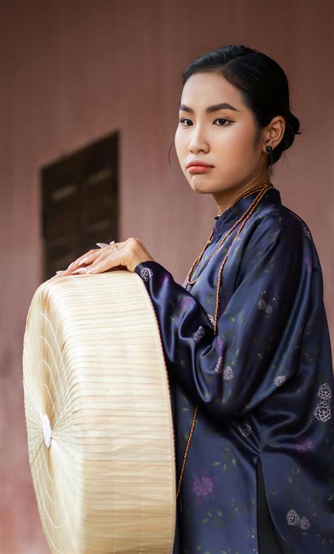 Chapéucònicasiatisk 거리 거리 장면 거리 패션 건축 고깔형 모자 관광 긴 머리 꽃무늬 디자인 노란 드레스 노란색 도시 설정 도시의